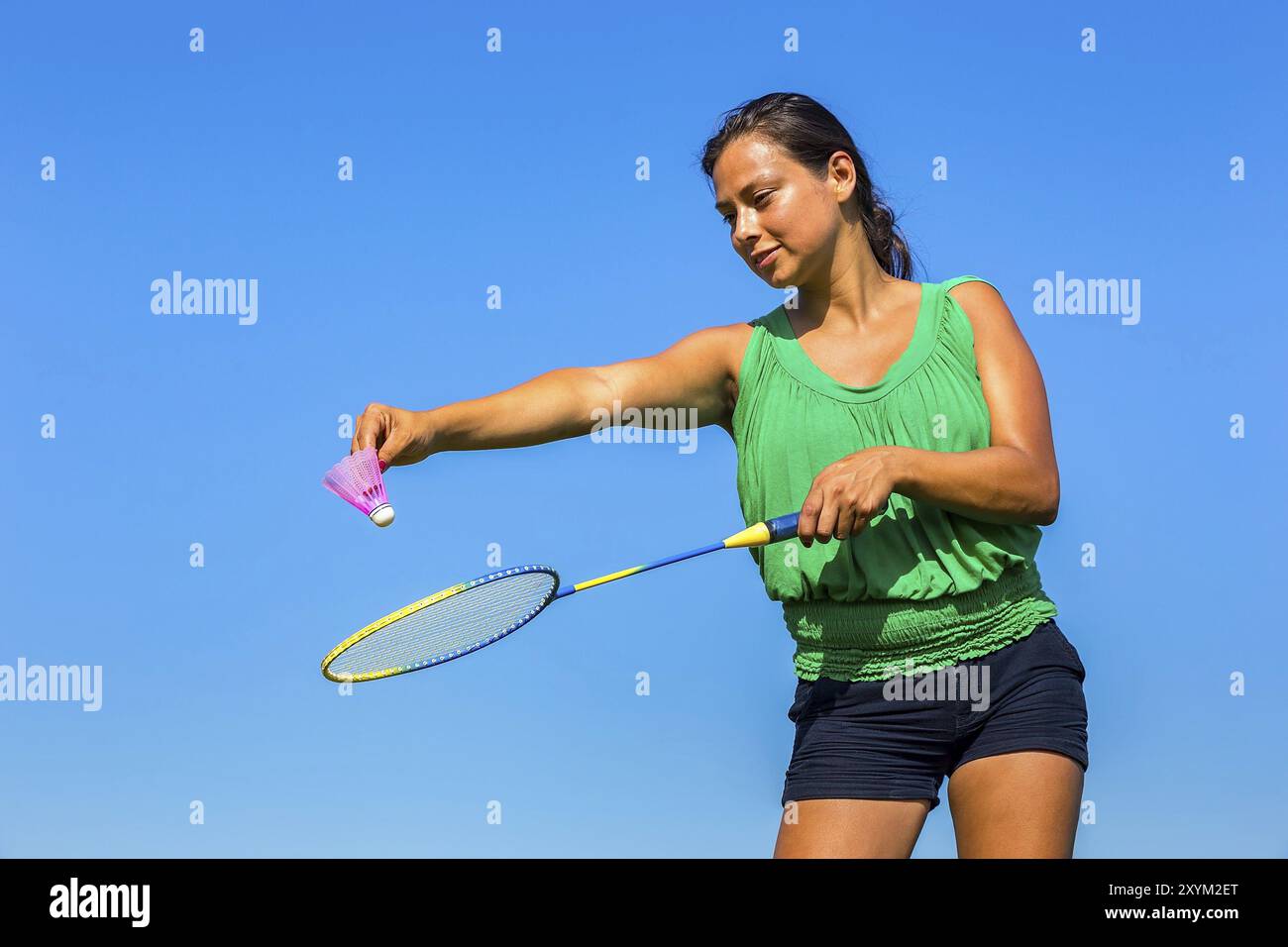 Young Colombian woman serve with badminton racket and shuttle in front ...