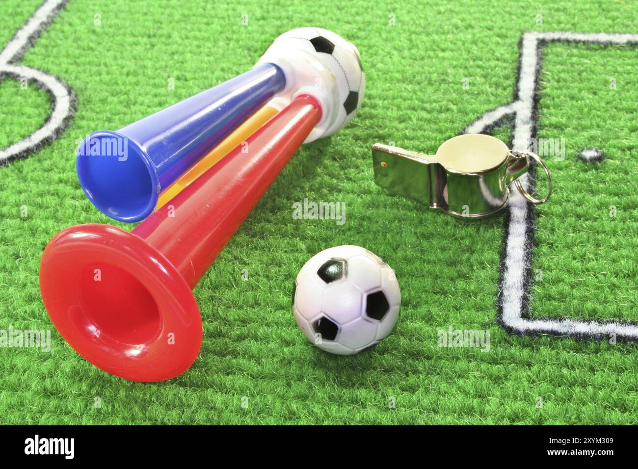 Colourful football horn with football and whistle on a football pitch ...
