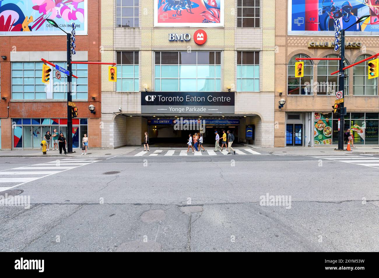 People walking by the Eaton Centre parking lot entrance, with the ...