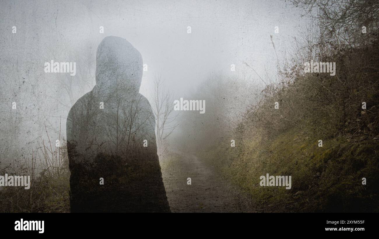 A double exposure of a ghost like hooded figure. Standing on a spooky ...