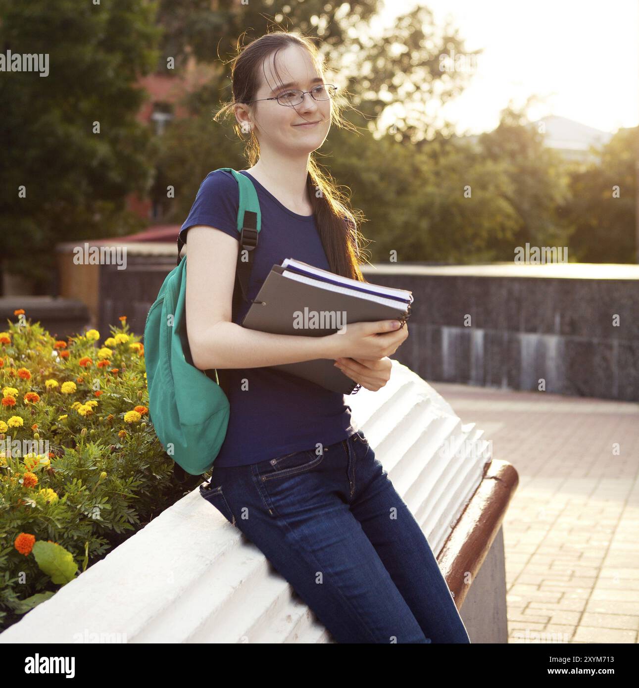 Female smiling student outdoors holding notebooks in the evening Stock ...