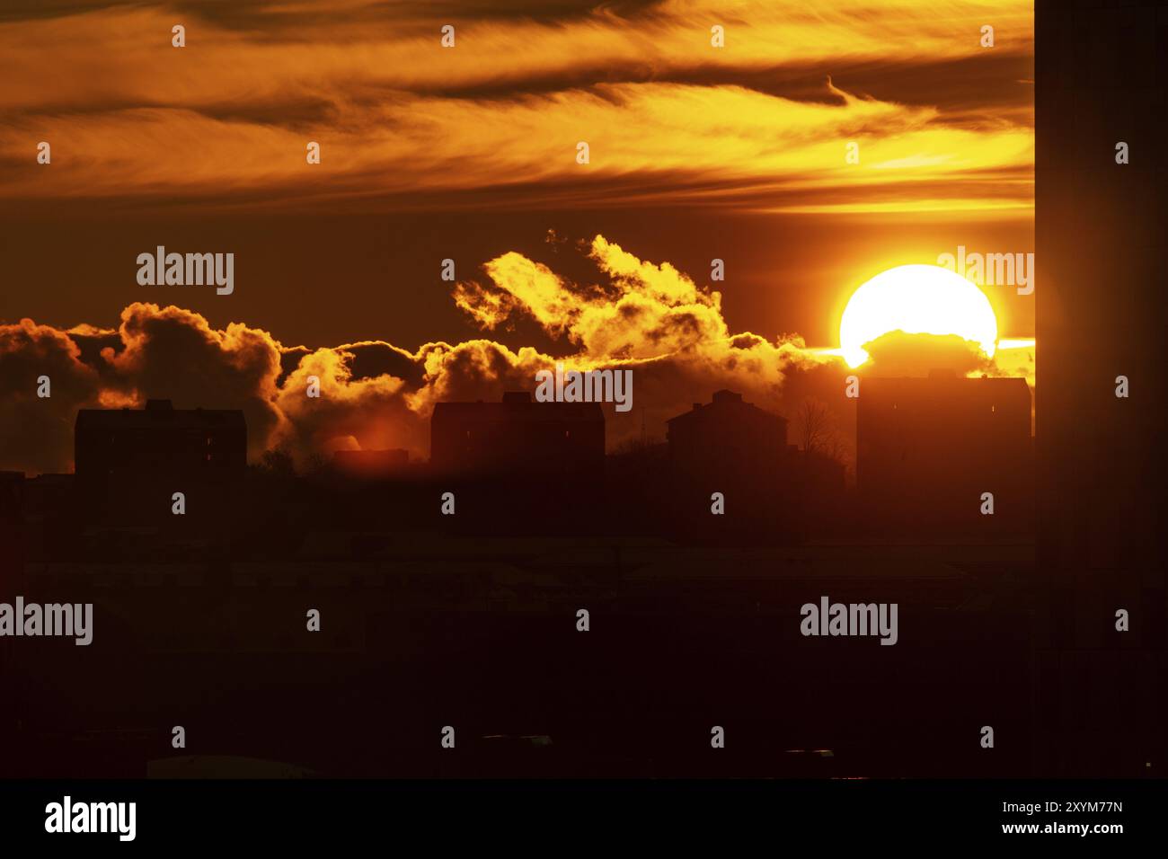 Sun setting behind apartment buildings Stock Photo - Alamy