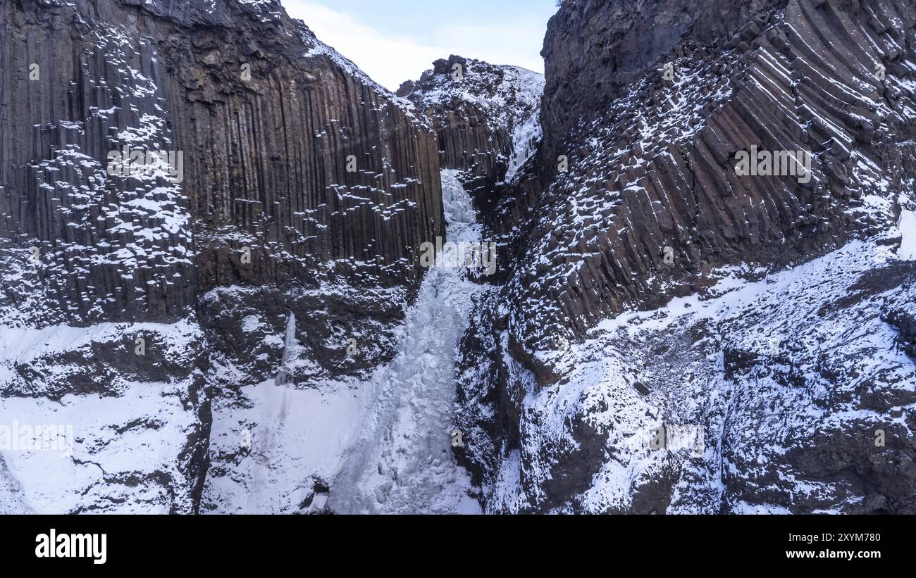 The beautiful Hengifoss waterfall frozen in the cold winter of Iceland ...