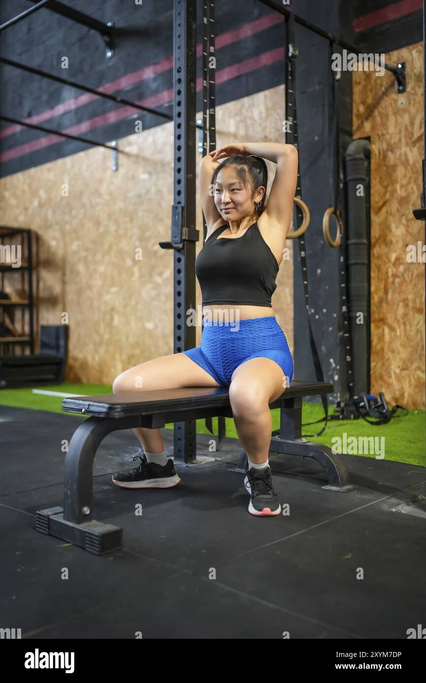 Vertical photo of a female beauty fit Chinese athlete warming up in a cross training gym Stock ...