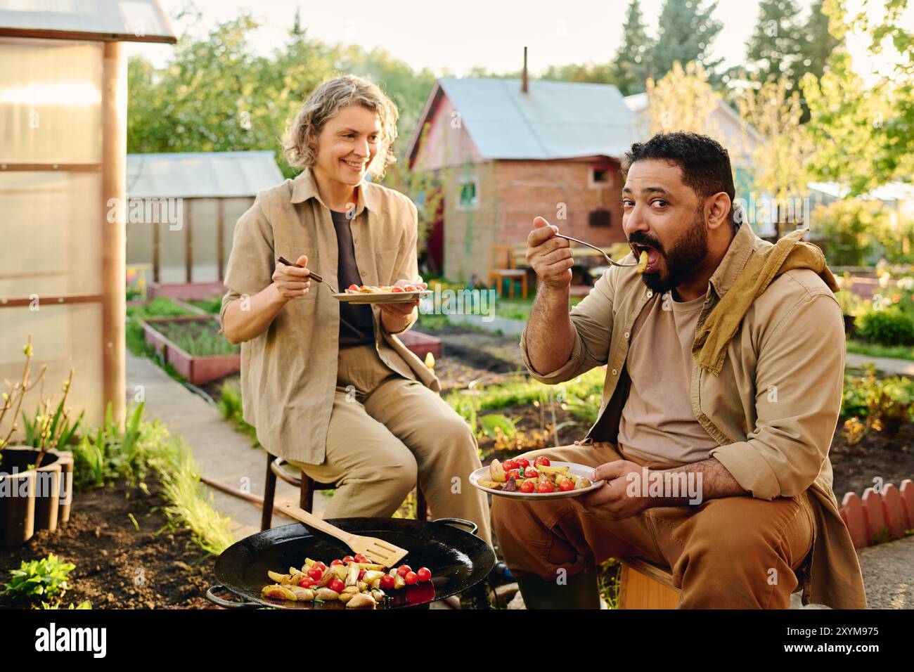 Mature Hispanic man eating vegetable stew and looking at camera while ...