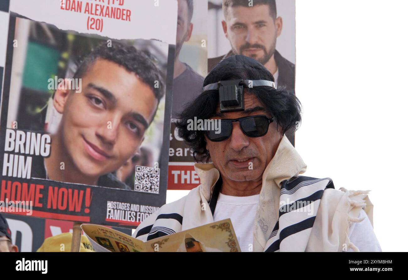NIRIM, ISRAEL - AUGUST 29: Wrapped in a Jewish prayer shawl, the father ...