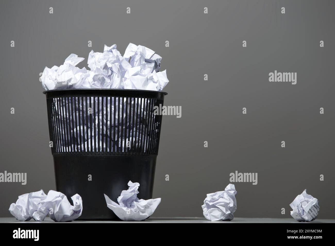 Recycle bin filled with crumpled papers. Gray background Stock Photo ...