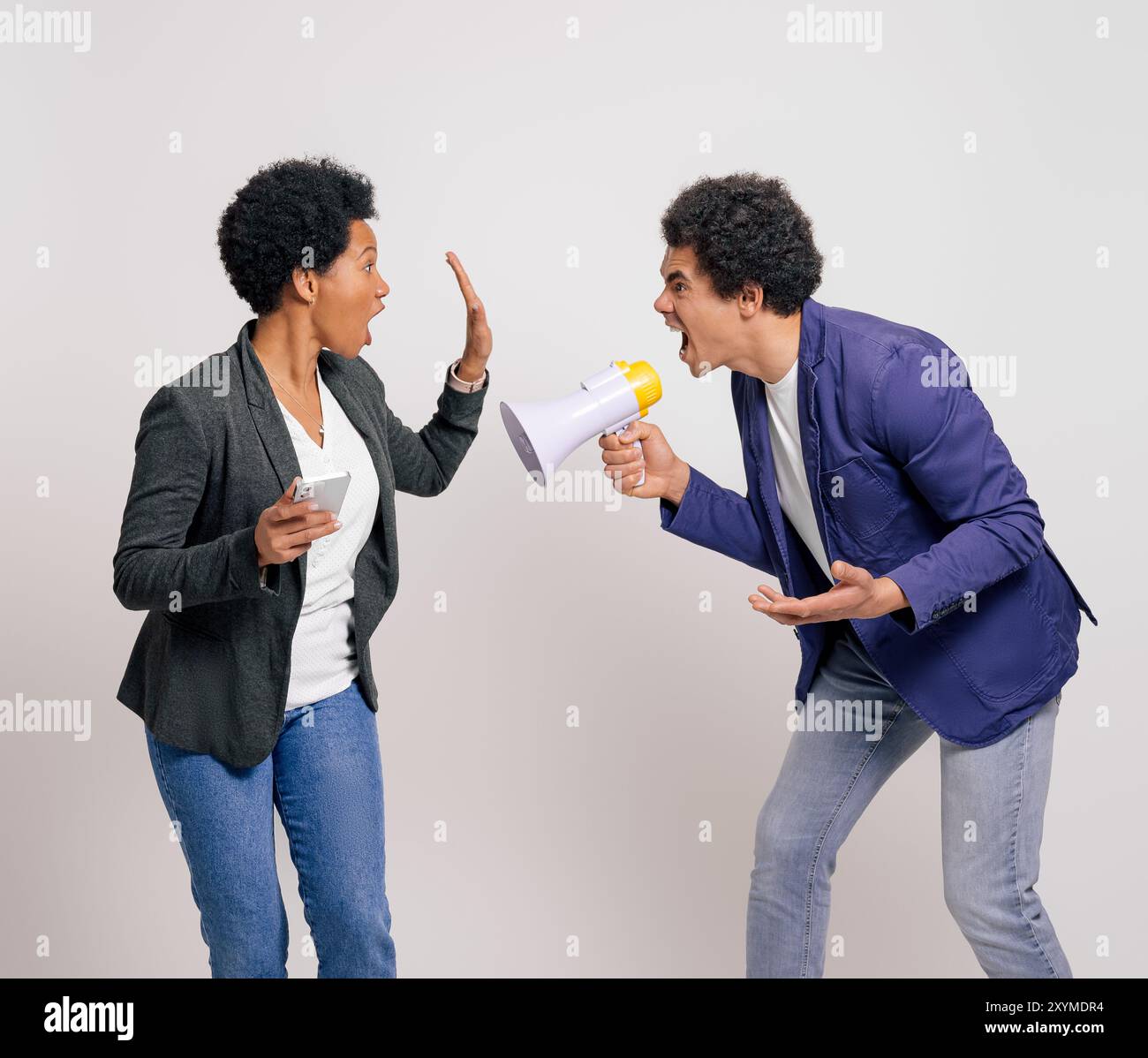 Young businessman with megaphone screaming at female partner showing ...