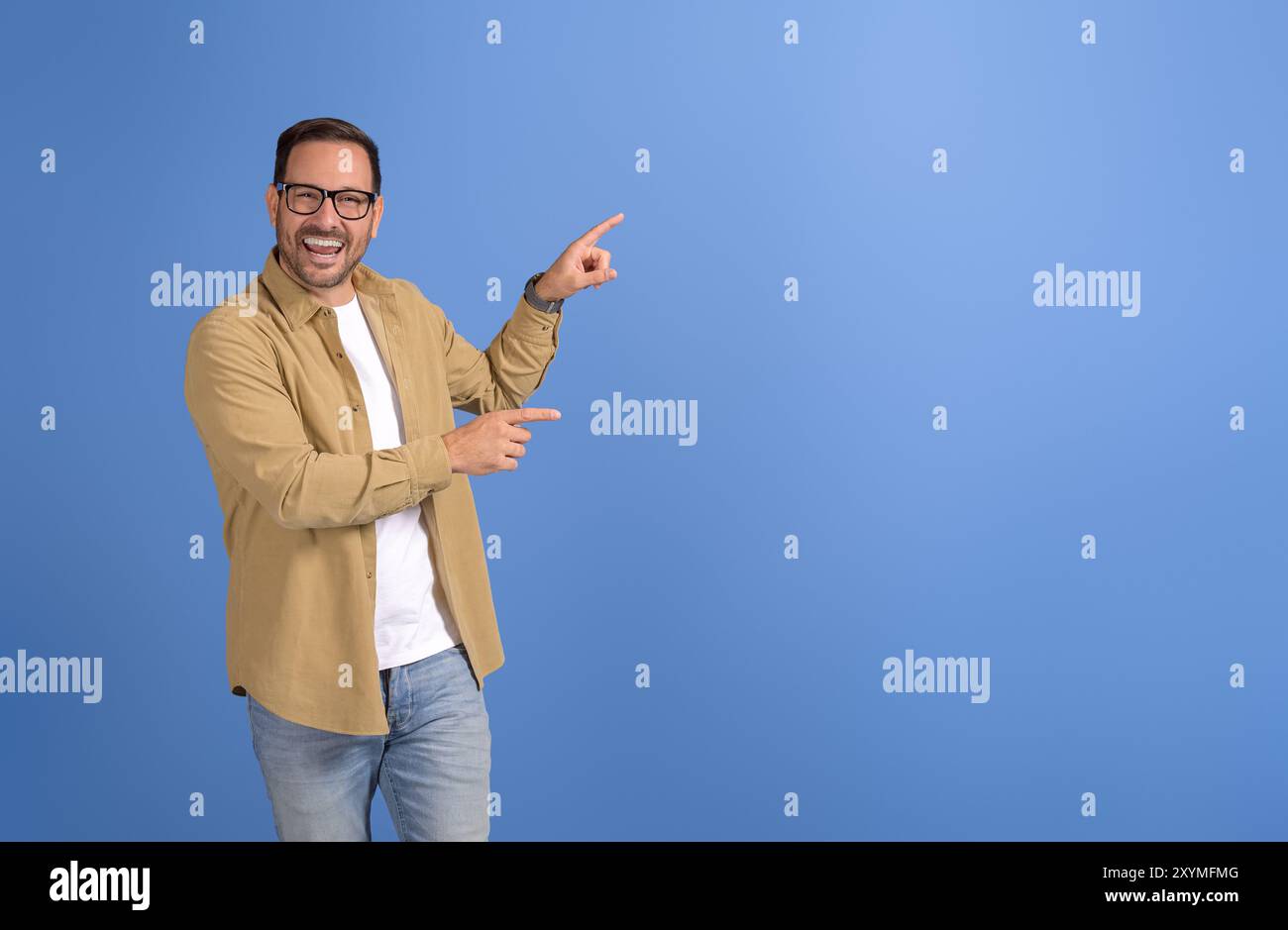 Portrait of young salesman laughing and aiming at empty space for ...