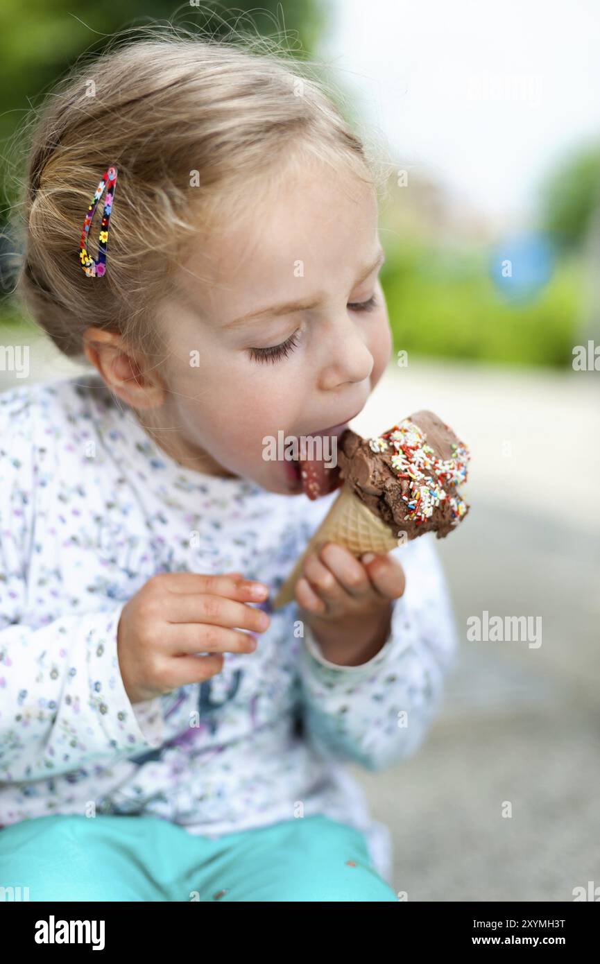 Very cute little with blonde hair eating ice cream and is completely ...