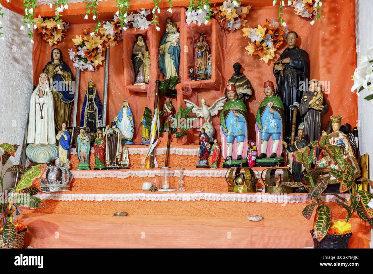 Colorful altar with several Catholic saints decorated with plants and ...