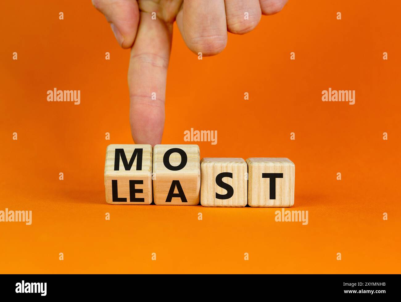 Most or least symbol. Businessman turns beautiful wooden cubes and ...