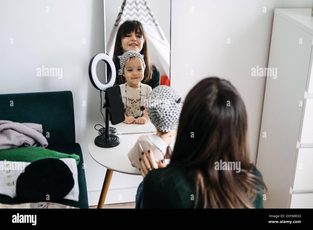 Toddler exploring self-discovery through mirror play with mother. Child ...