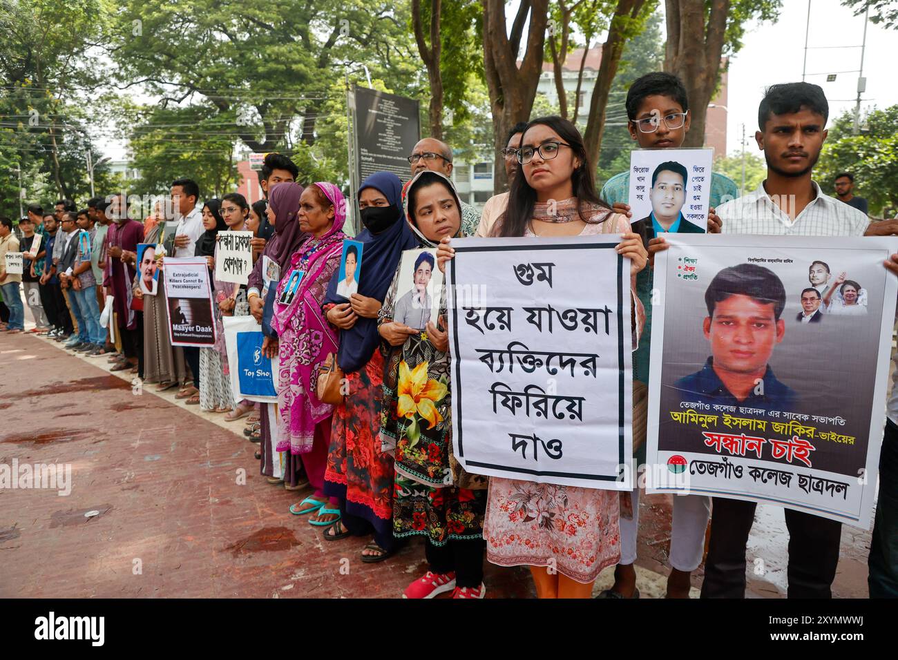 People hold pictures of family members who went missing, during an ...