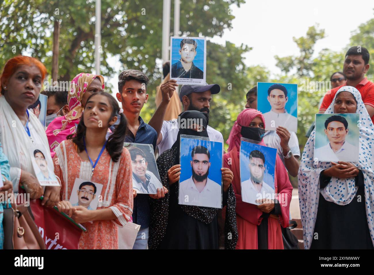People hold pictures of family members who went missing, during an ...