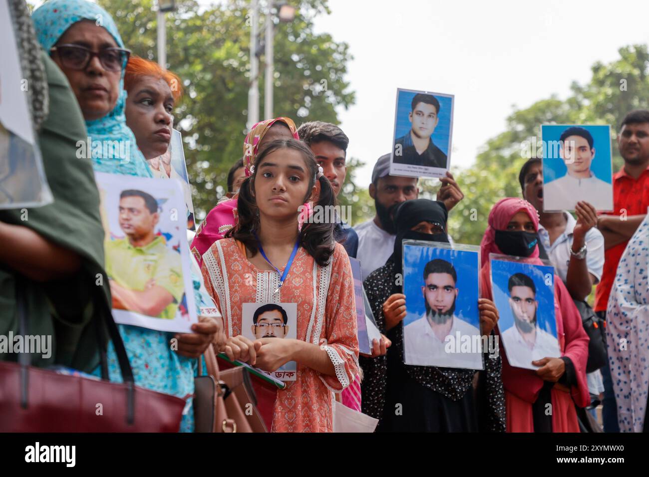 People hold pictures of family members who went missing, during an ...