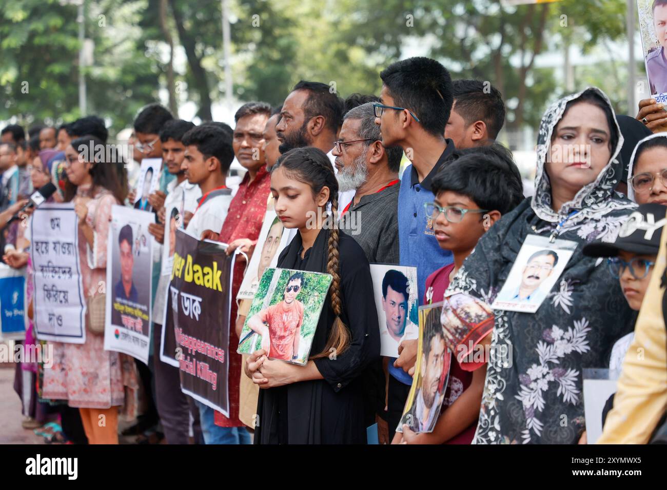 People hold pictures of family members who went missing, during an ...