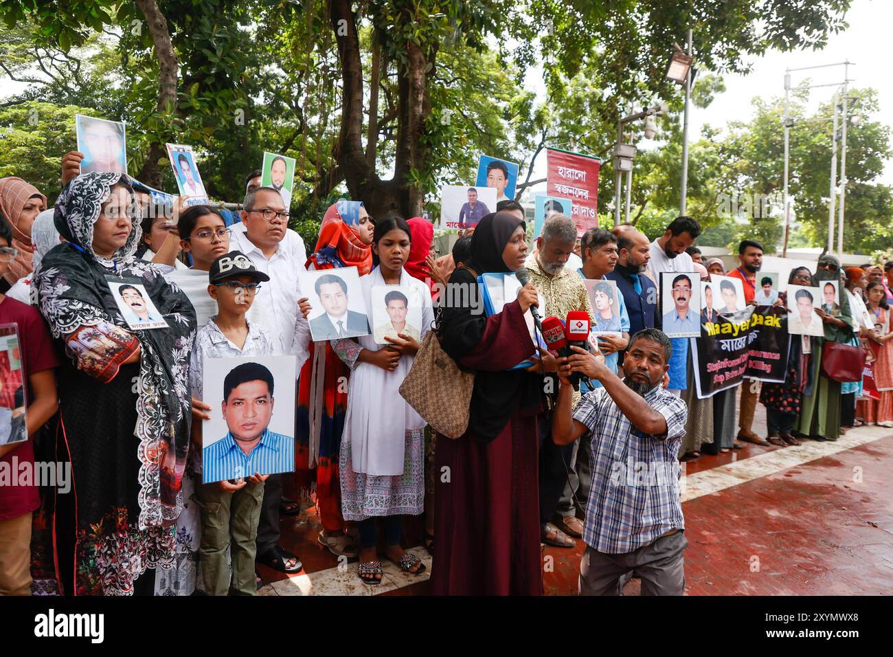 People hold pictures of family members who went missing, during an ...