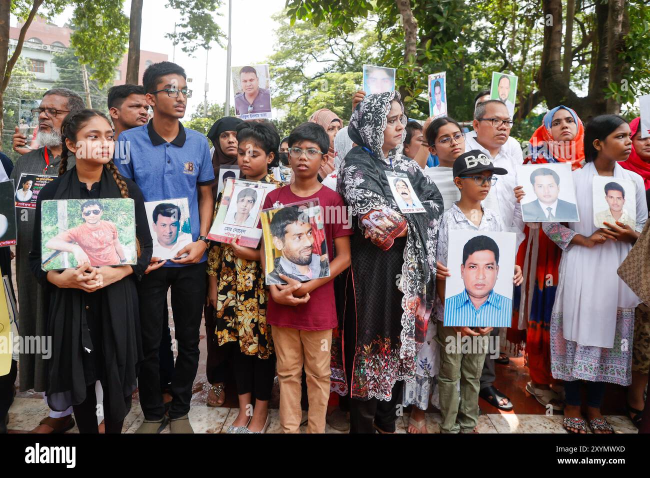 People hold pictures of family members who went missing, during an ...