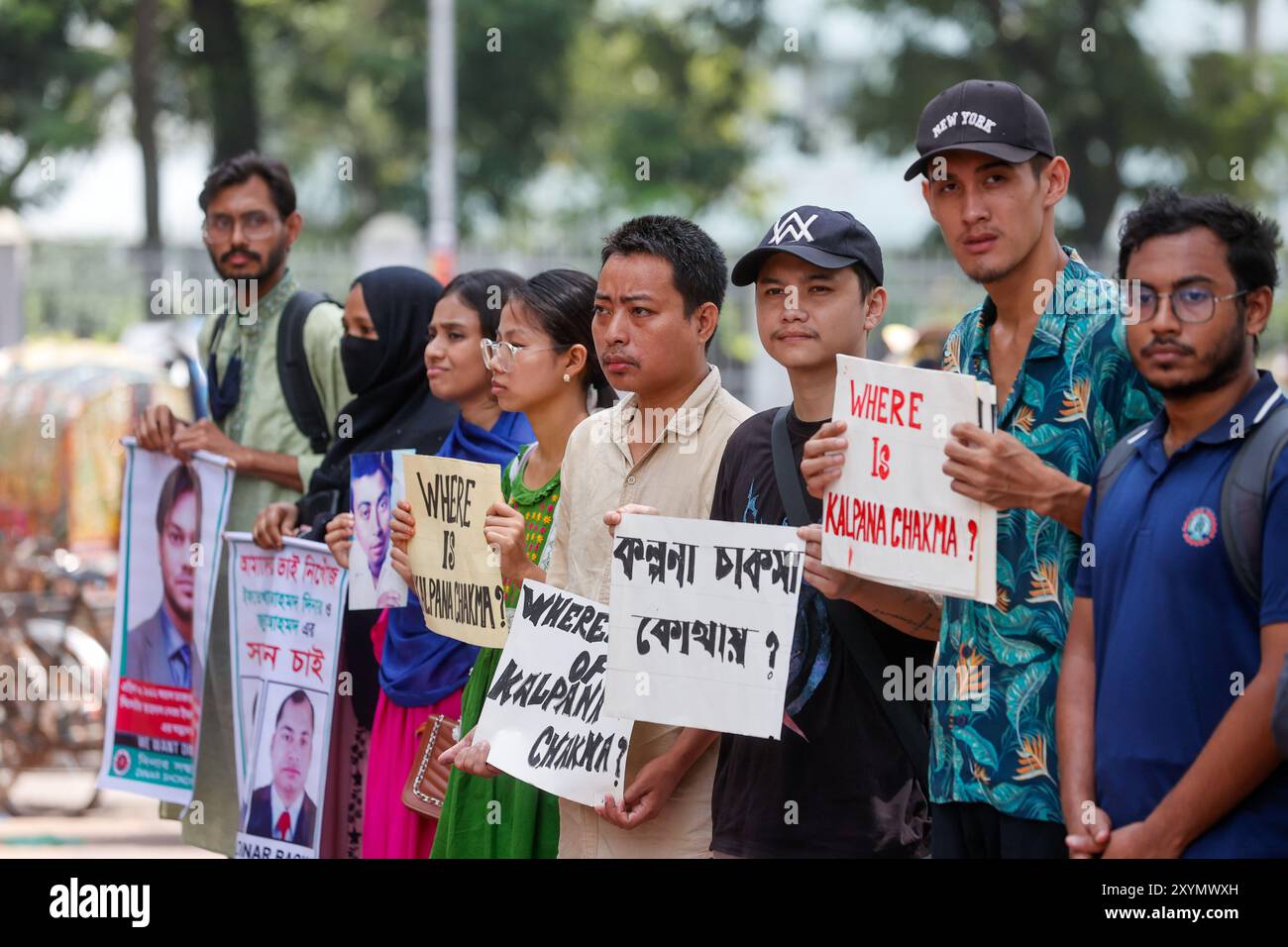 People hold pictures of family members who went missing, during an ...