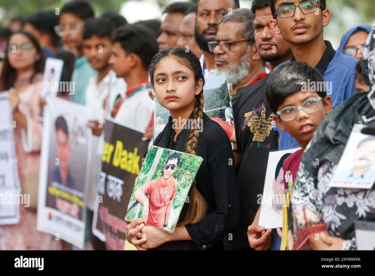 People hold pictures of family members who went missing, during an ...