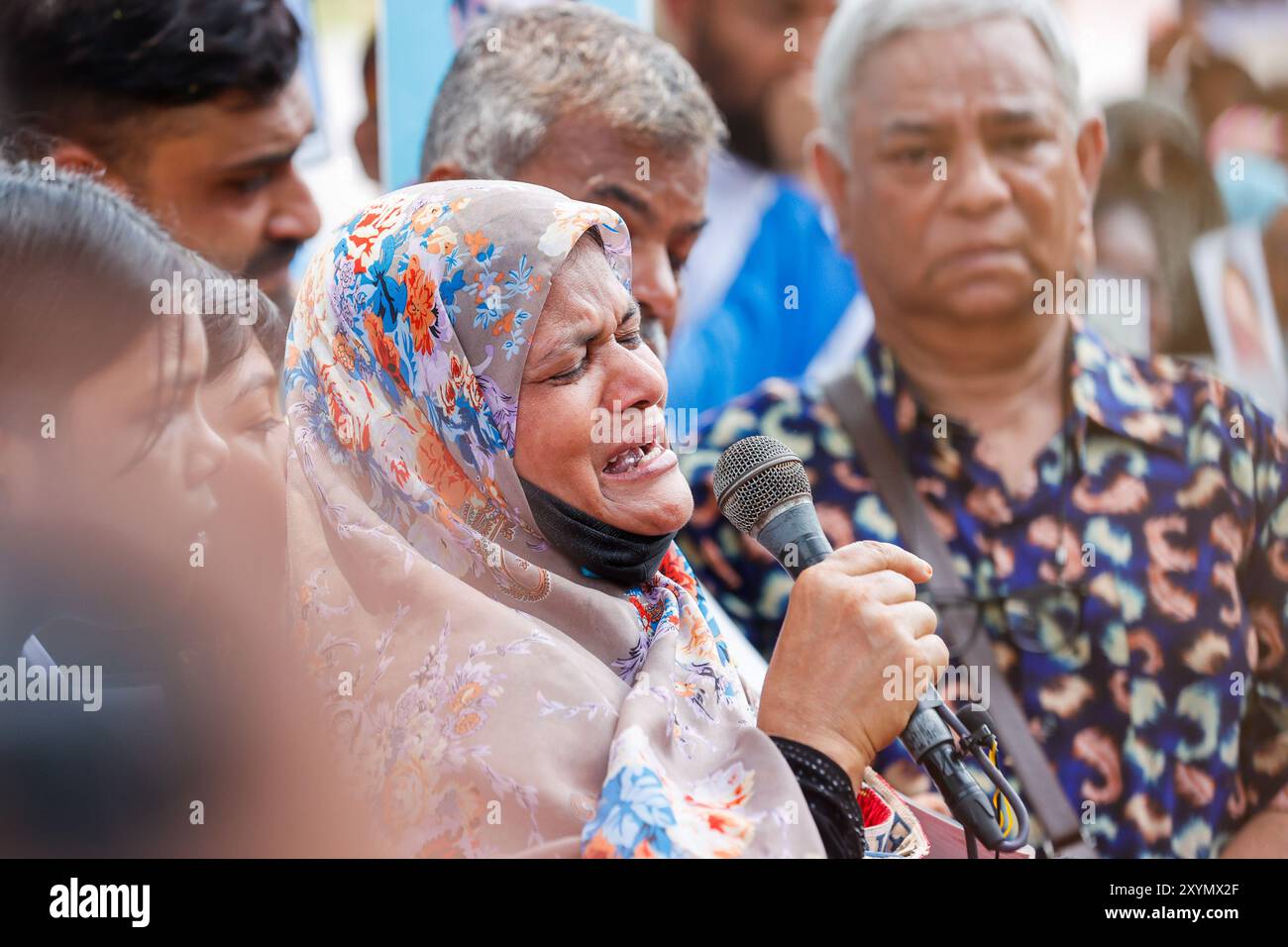 People hold pictures of family members who went missing, during an ...