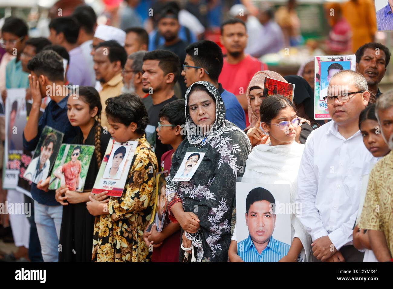 People hold pictures of family members who went missing, during an ...