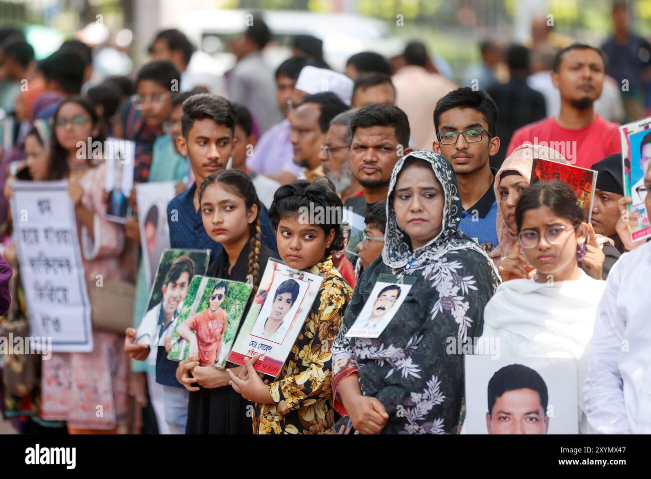 People hold pictures of family members who went missing, during an ...
