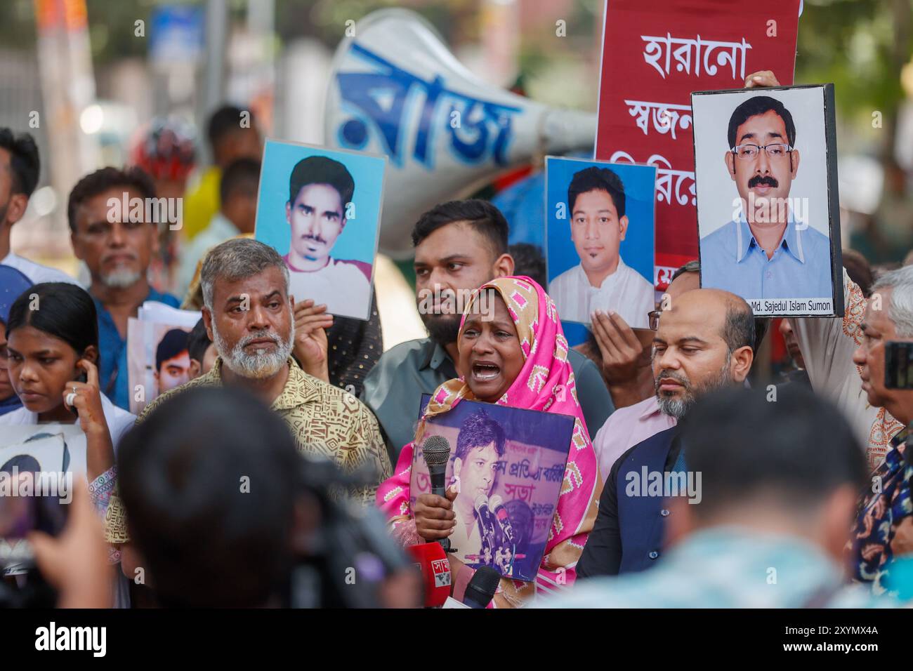 People hold pictures of family members who went missing, during an ...