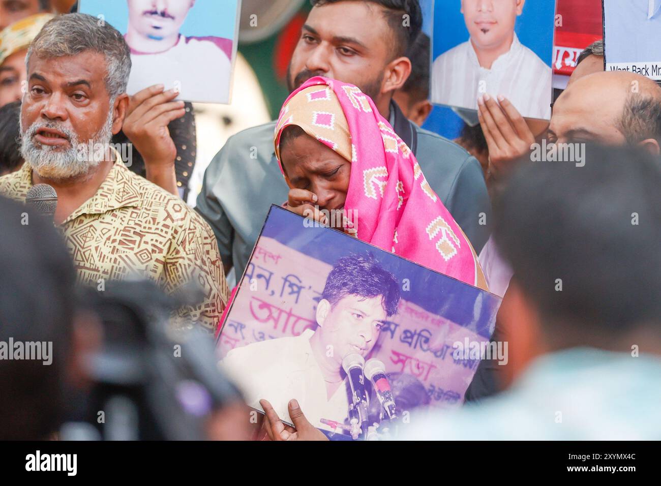 People hold pictures of family members who went missing, during an ...
