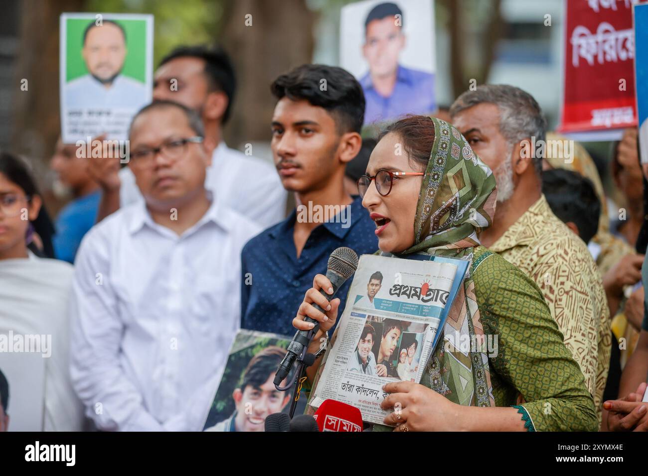 People hold pictures of family members who went missing, during an ...