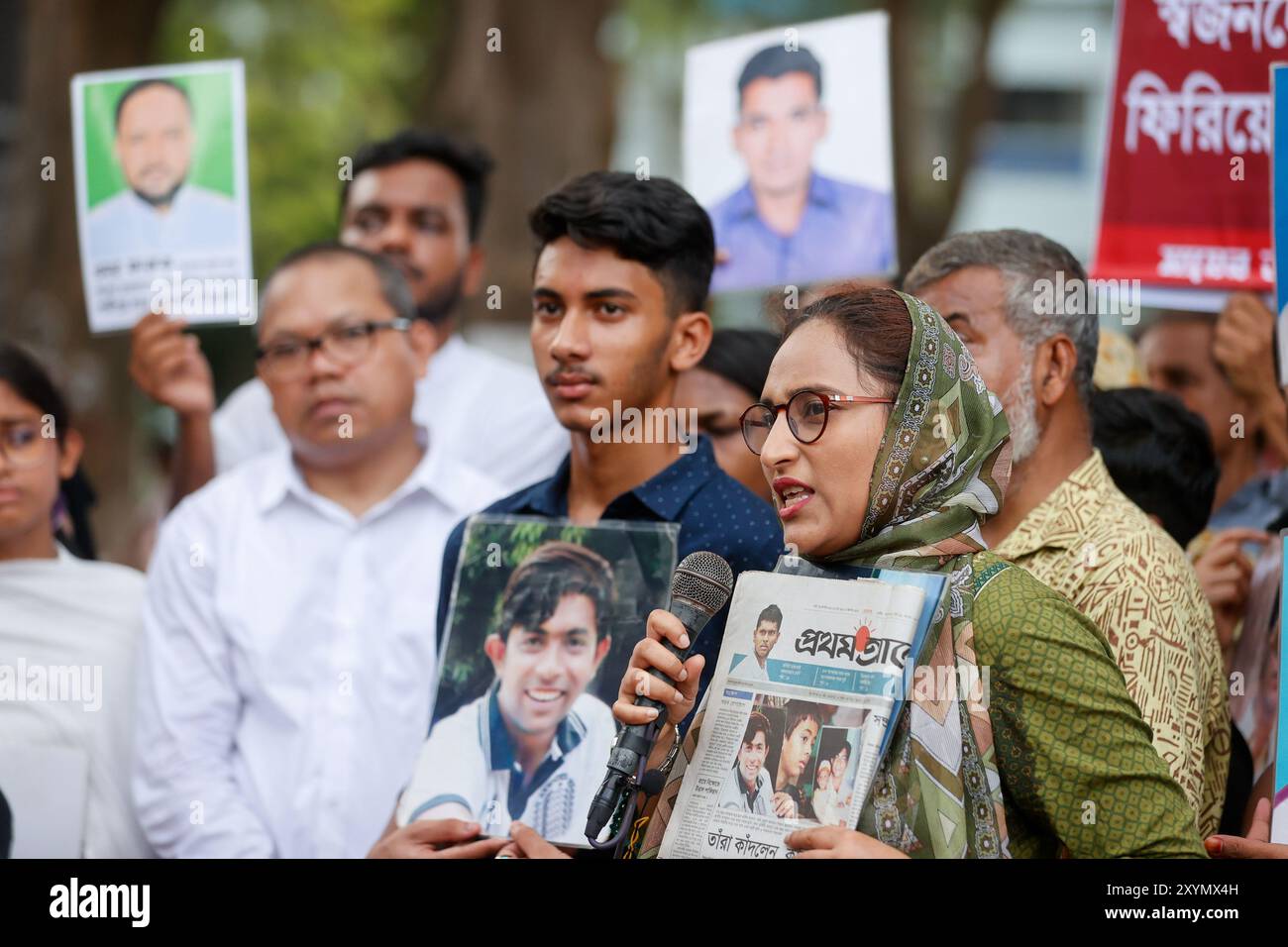 People hold pictures of family members who went missing, during an ...