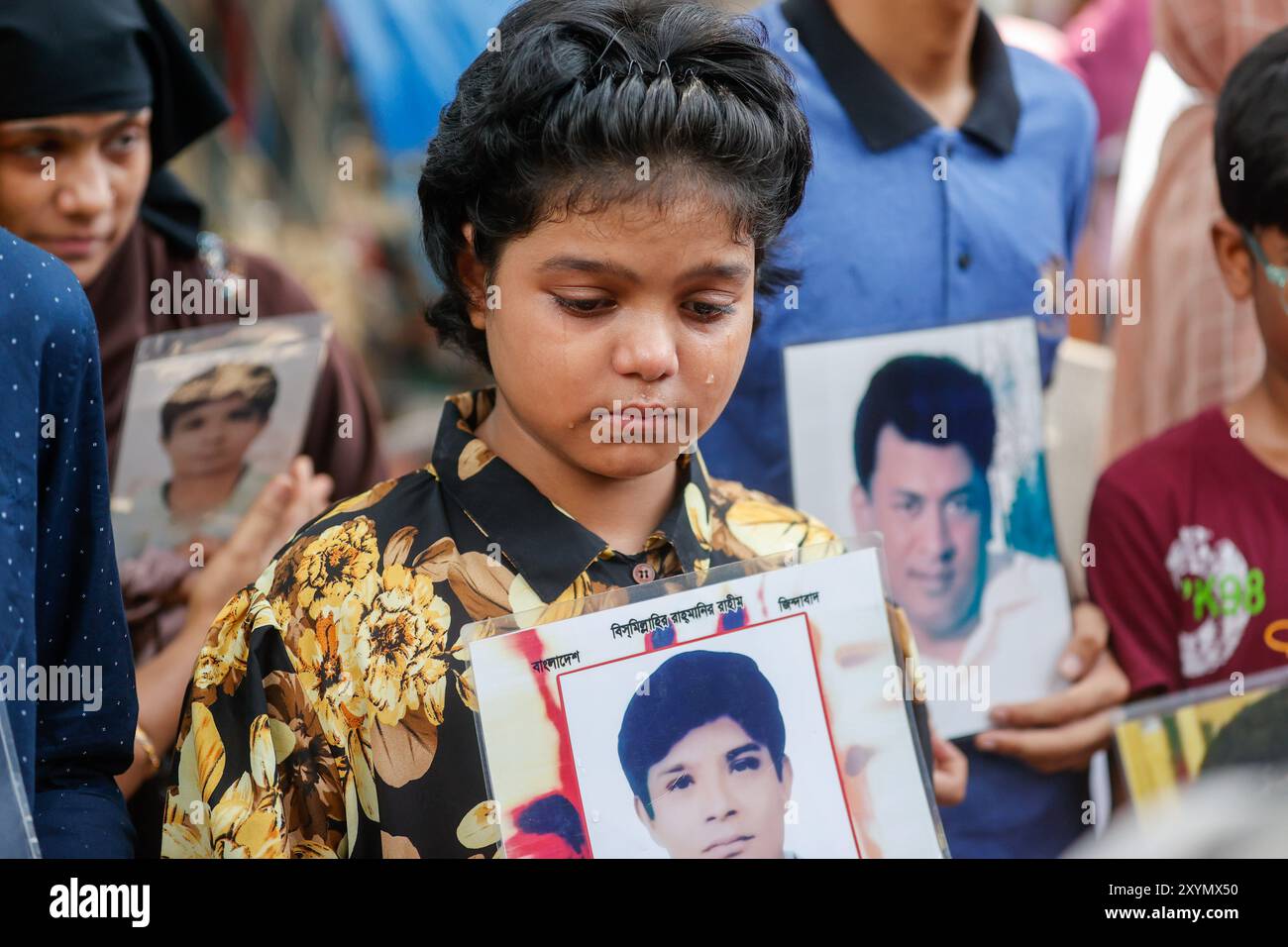 People hold pictures of family members who went missing, during an ...
