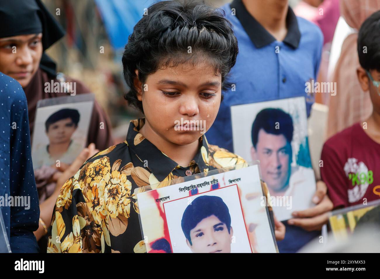 People hold pictures of family members who went missing, during an ...
