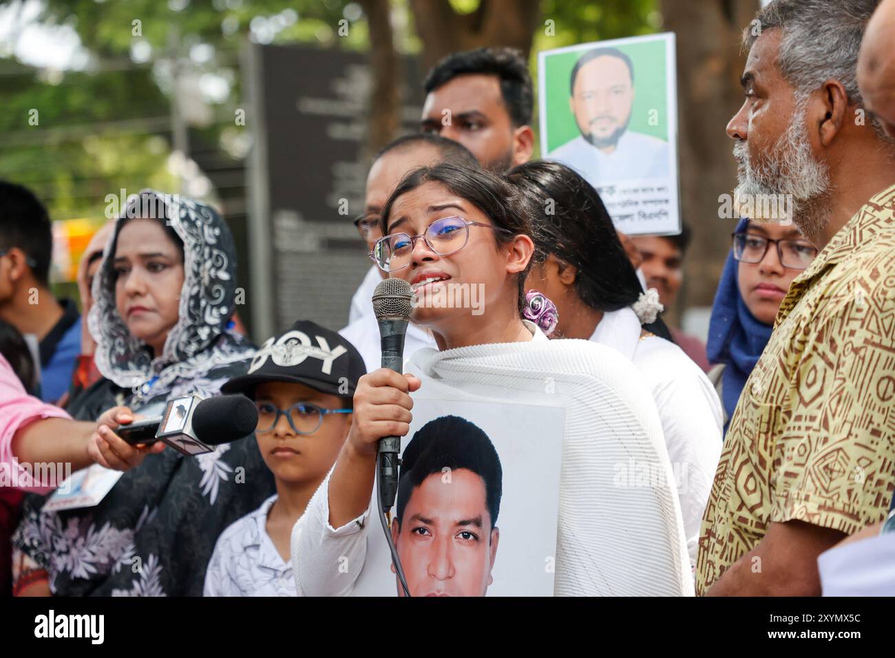 People hold pictures of family members who went missing, during an ...