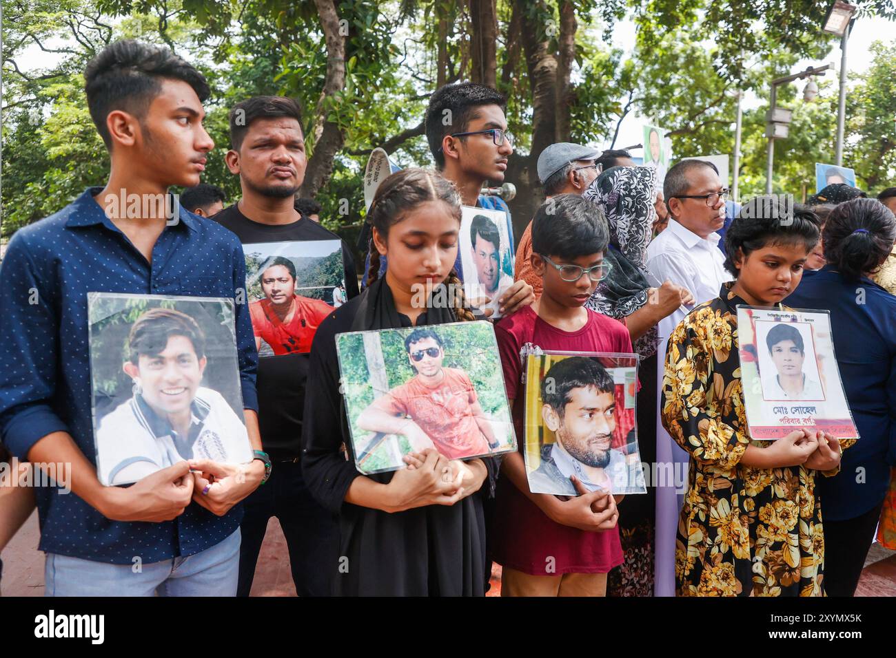 People hold pictures of family members who went missing, during an ...