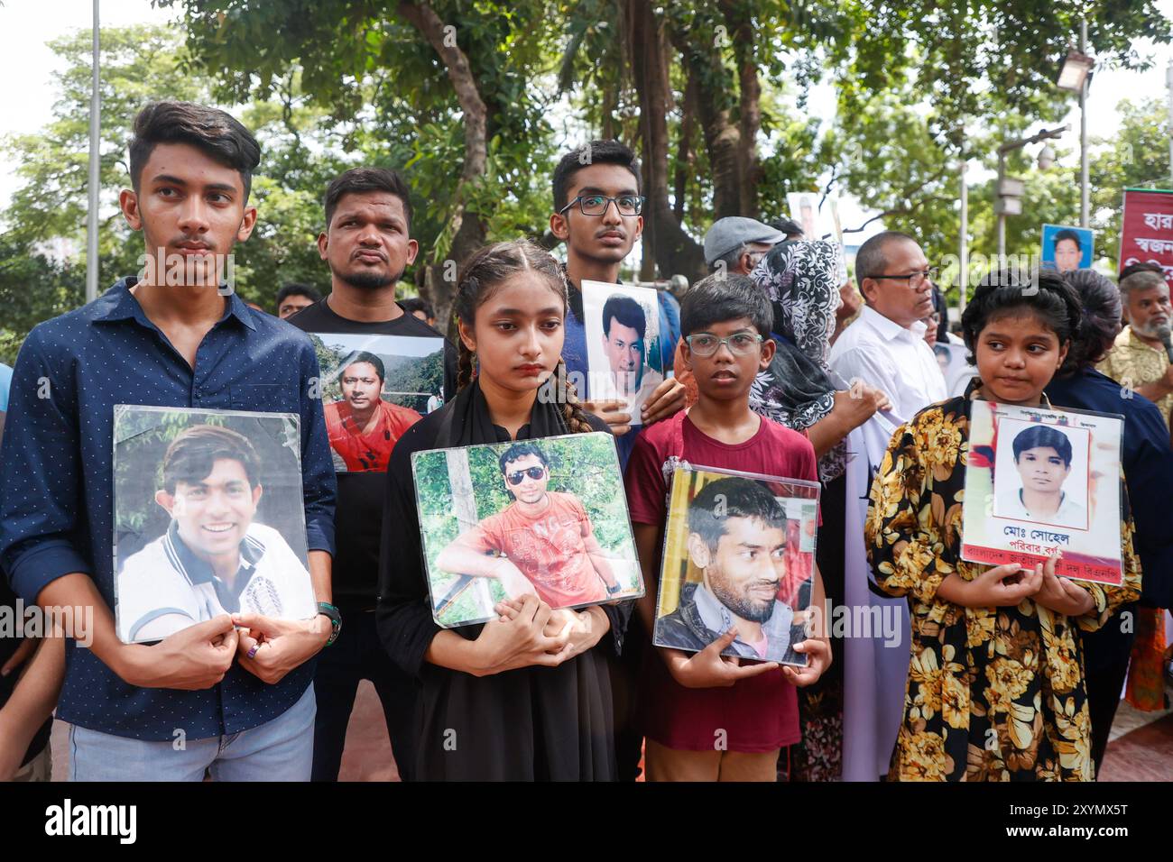 People hold pictures of family members who went missing, during an ...