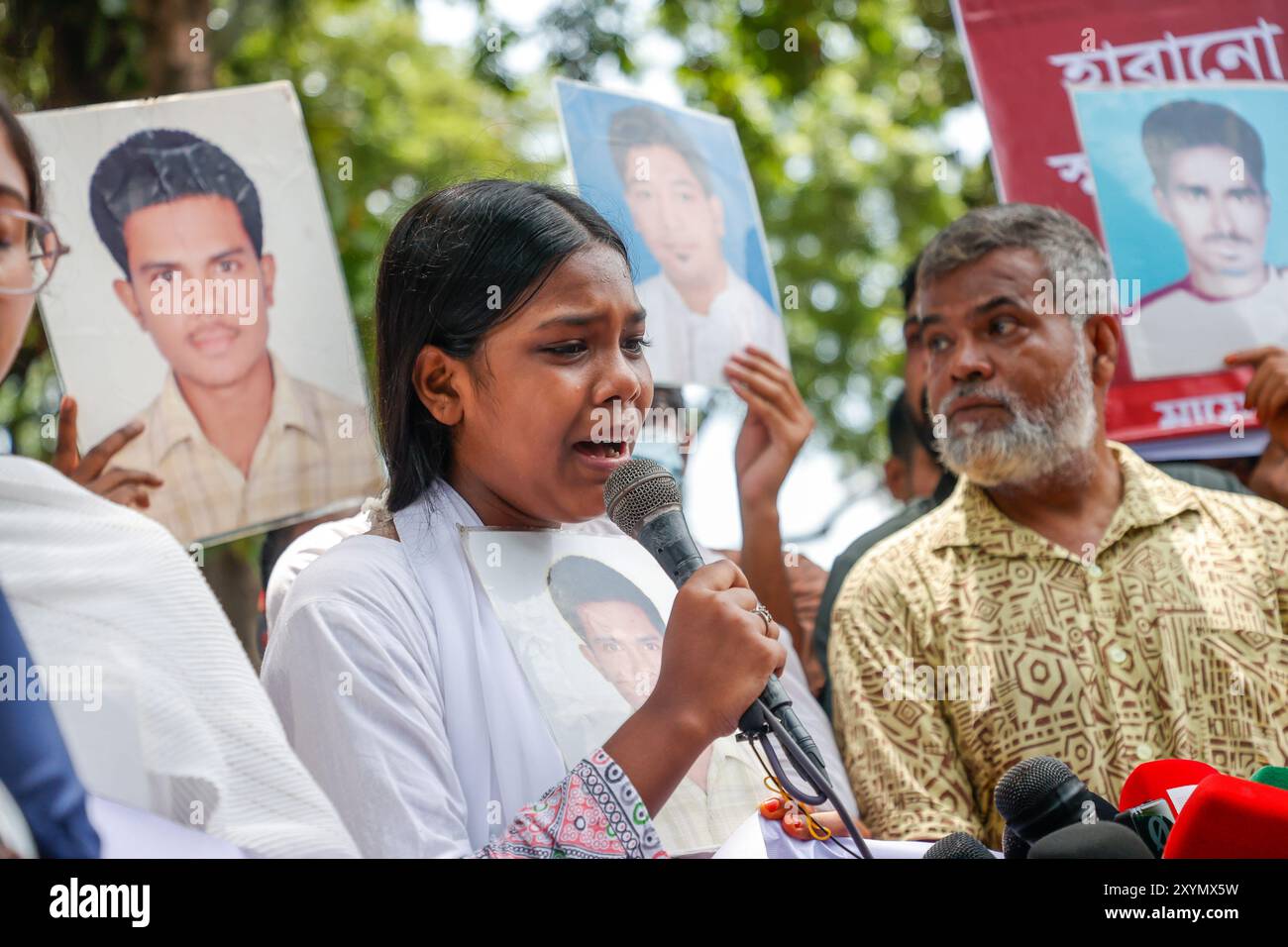 People hold pictures of family members who went missing, during an ...