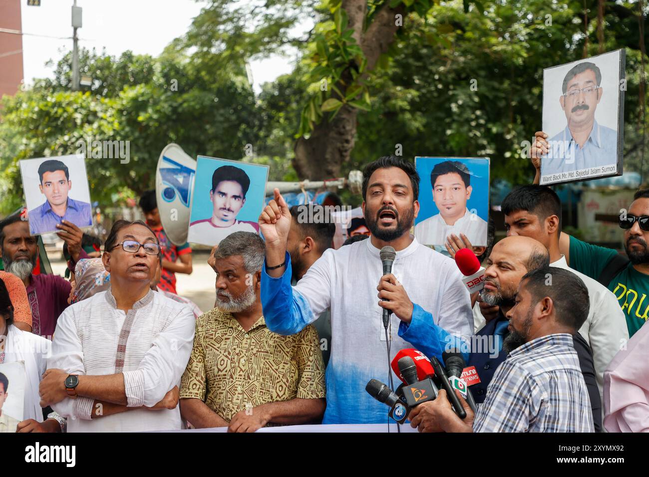 People hold pictures of family members who went missing, during an ...