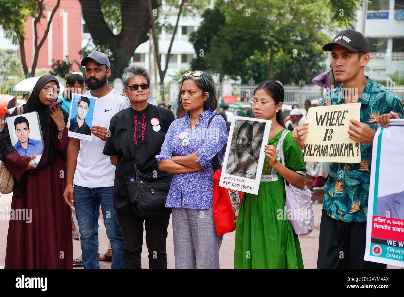 People hold pictures of family members who went missing, during an ...