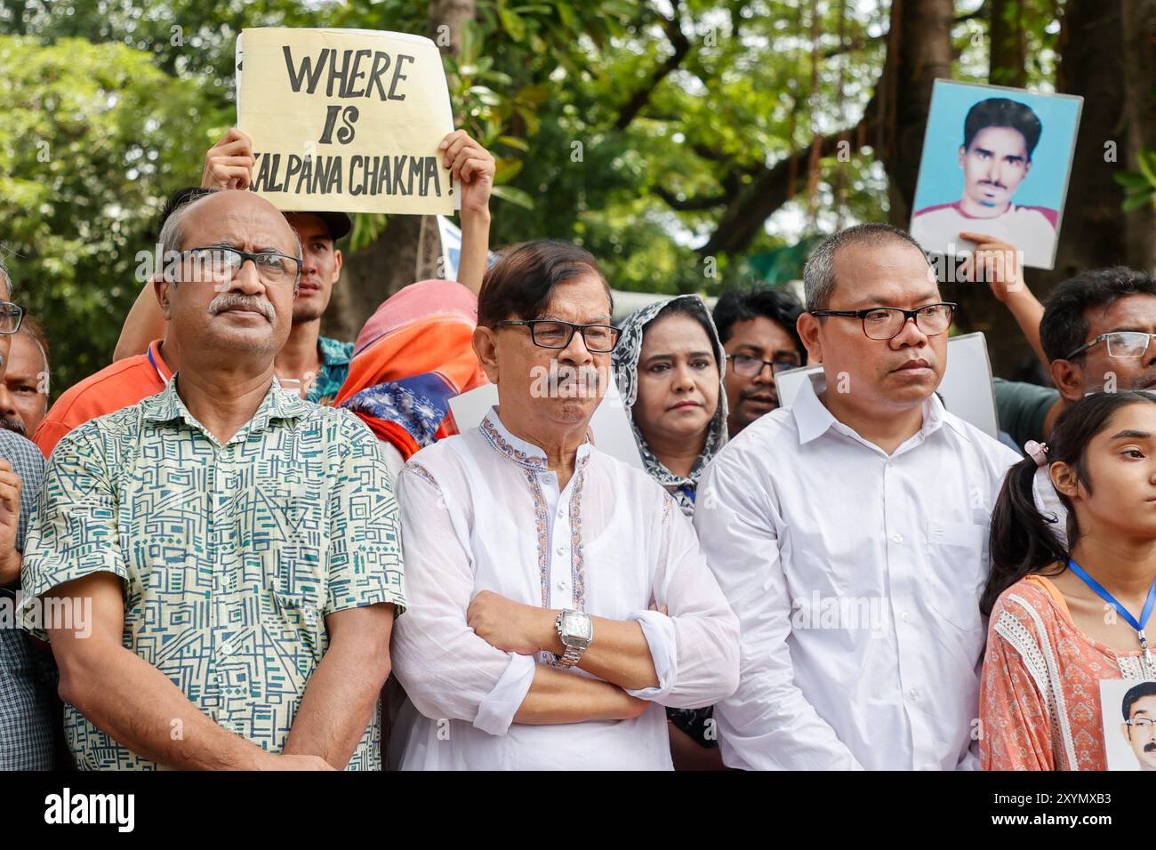 People hold pictures of family members who went missing, during an ...