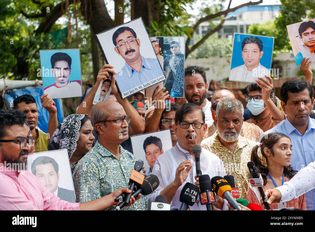 People hold pictures of family members who went missing, during an ...