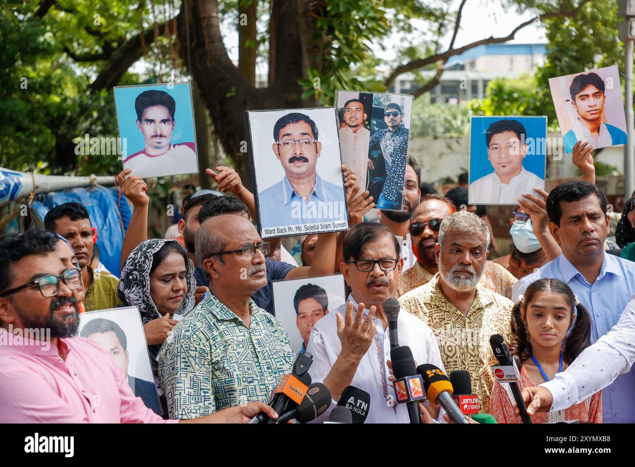 People hold pictures of family members who went missing, during an ...