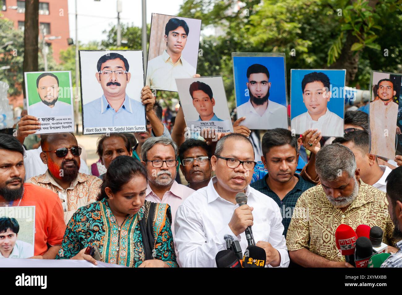 People hold pictures of family members who went missing, during an ...