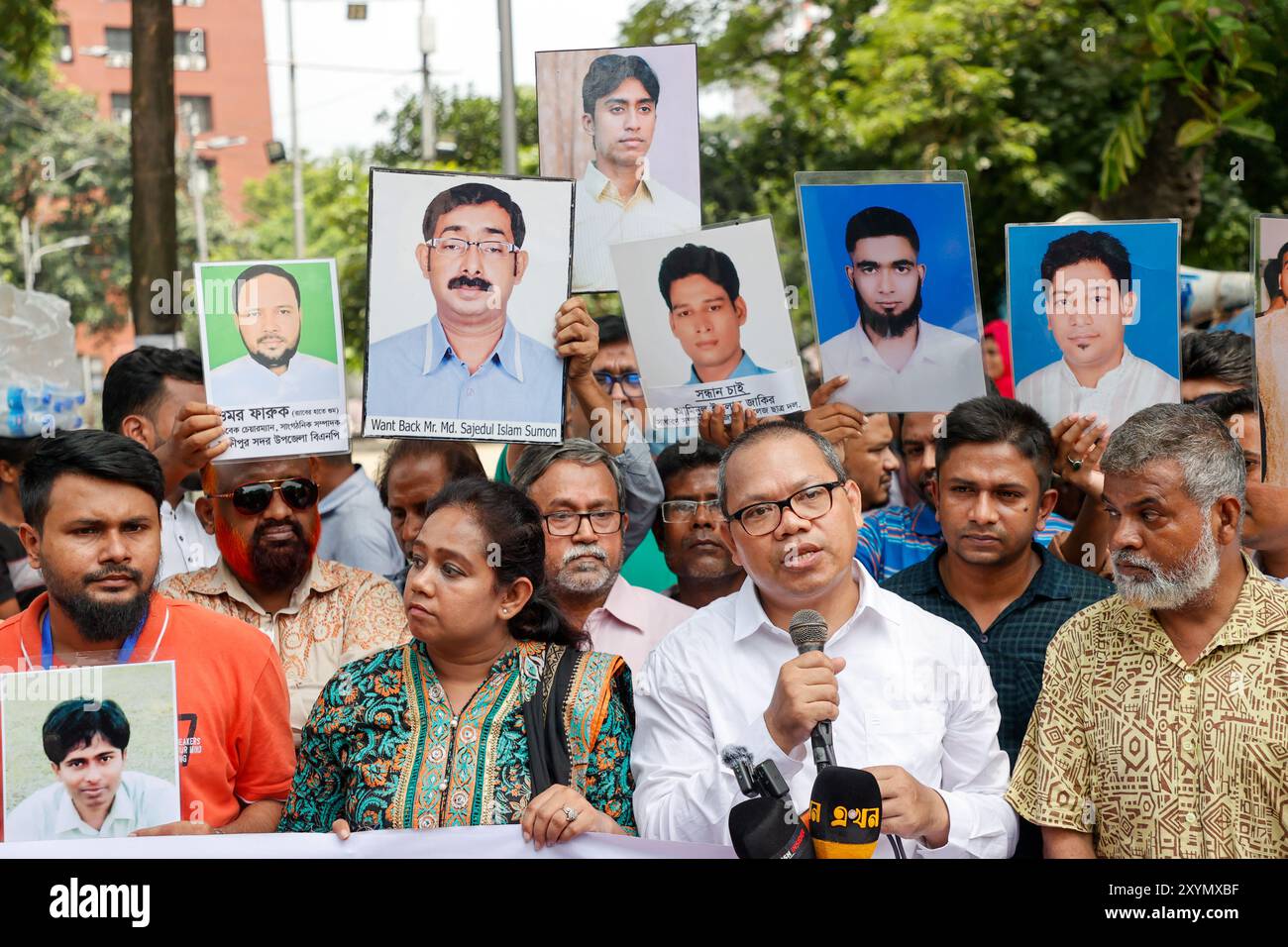 People hold pictures of family members who went missing, during an ...