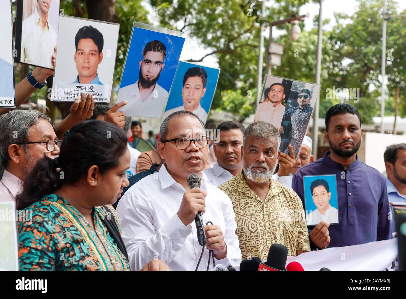 People hold pictures of family members who went missing, during an ...