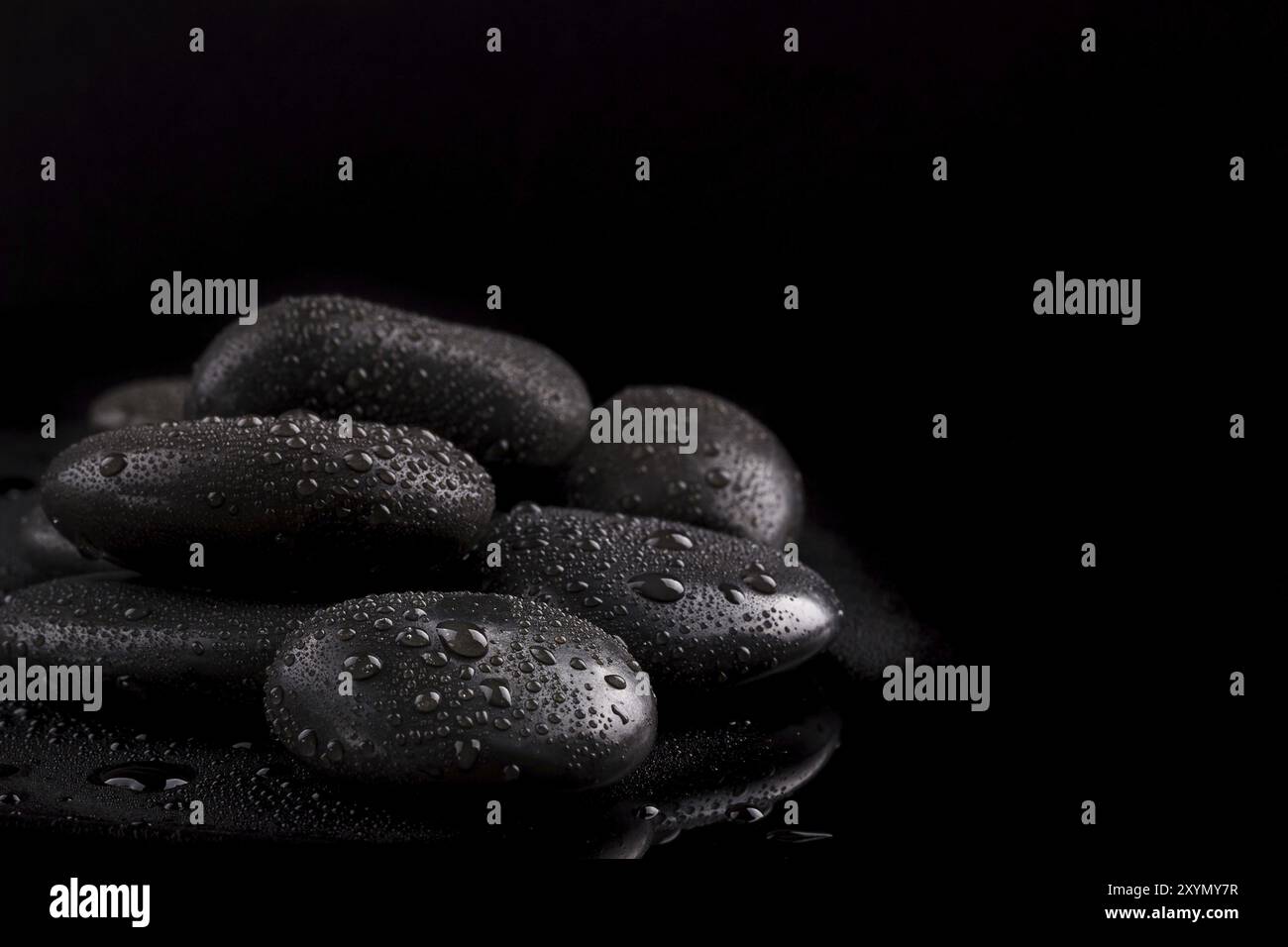 Zen basalt, black, wet stones on black background Stock Photo - Alamy