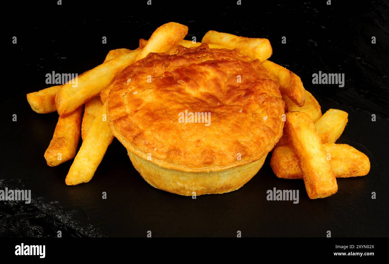 Steak and gravy puff pastry pie and chips meal Stock Photo - Alamy