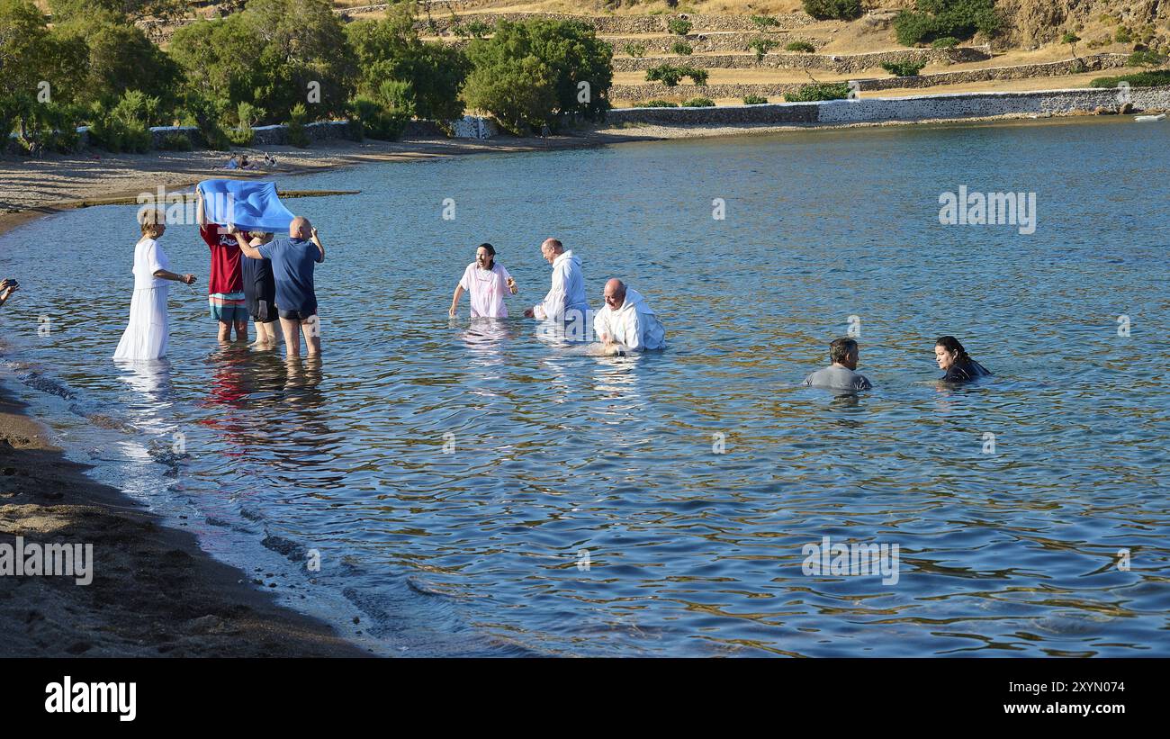 Men in white clothes and swimming costumes in the water, during a ...