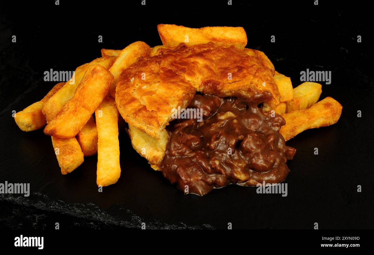 Steak and gravy puff pastry pie and chips meal Stock Photo - Alamy
